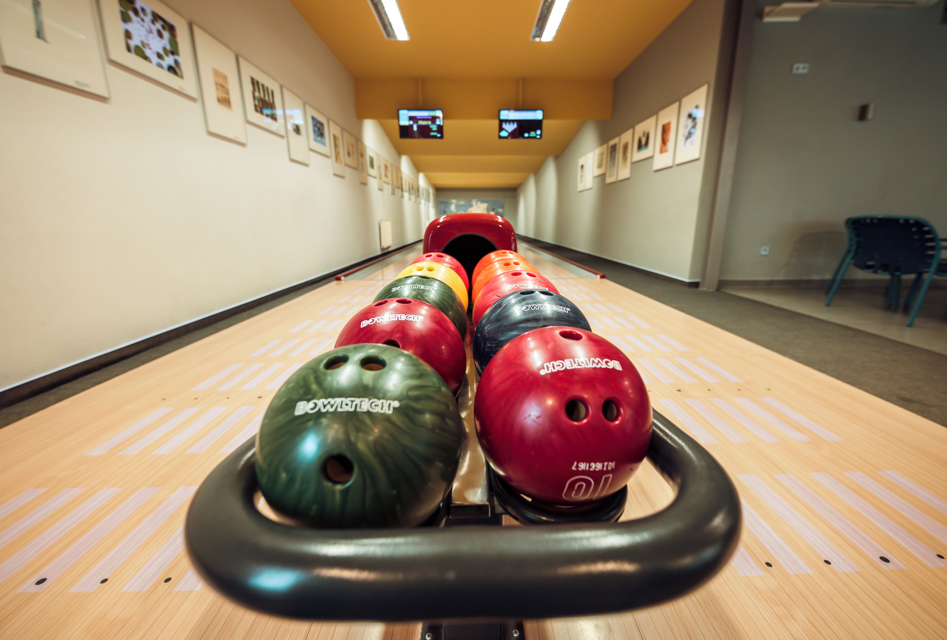 Uma pista de boliche com bolas e um suporte para pinos.