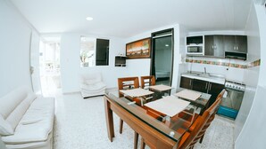 Um espaço compacto com área de refeições, cozinha compacta e sofá.