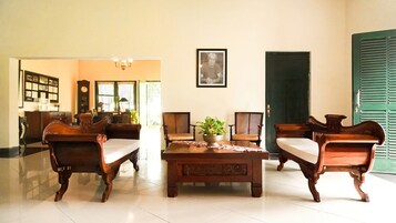 Quarto tradicional com móveis de madeira, um relógio e um quadro na parede.