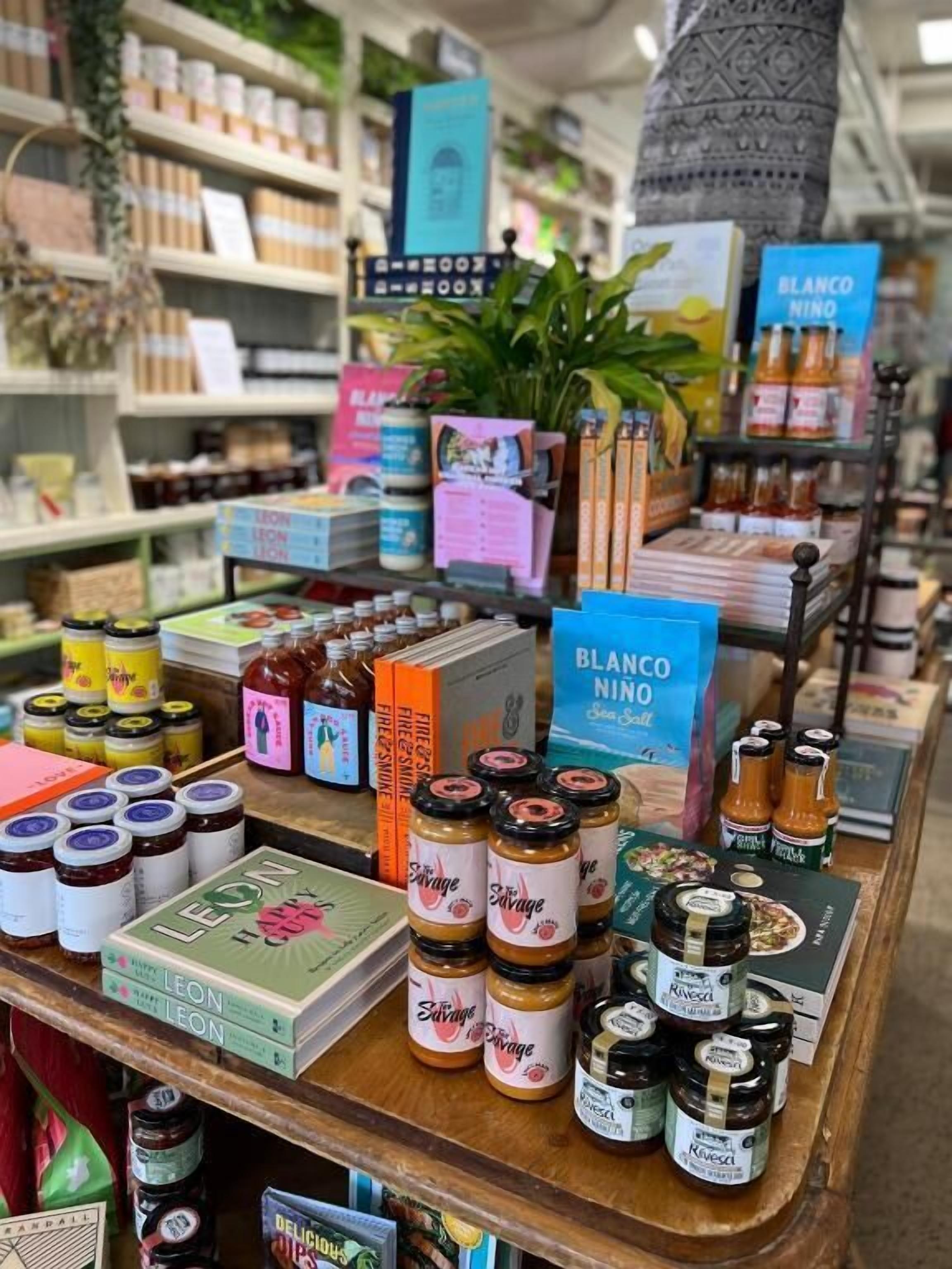 Exposição de diversos produtos alimentícios, incluindo potes de compotas e caixas de lanches, em um ambiente de loja.