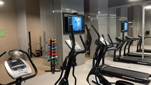 Uma academia com esteiras, elíptico e bicicleta ergométrica.
