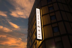 Um edifício com uma placa vertical exibindo caracteres japoneses.