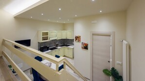 Uma cozinha moderna com armários claros, bancada preta e painel de azulejos.