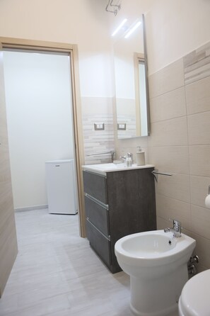 Quarto Deluxe | Casa de banho | Um polibã, um chuveiro fixo, artigos de higiene pessoal grátis, um bidé