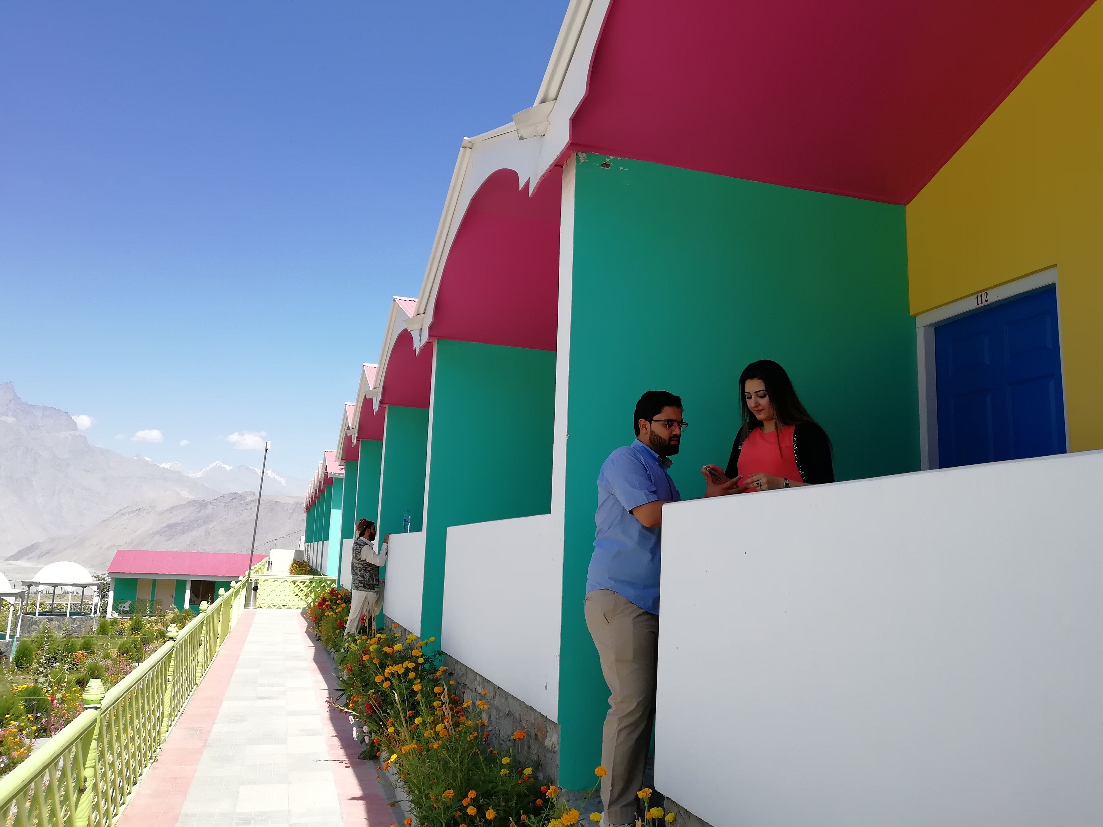 Fileira de quartos de hotel coloridos com vista para a montanha.