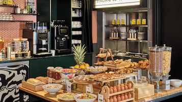 Buffet de café da manhã com diversos alimentos, máquinas de café e uma placa com a inscrição 'Italians do it better'.