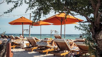 Praia particular, areia branca, espreguiçadeiras, guarda-sóis