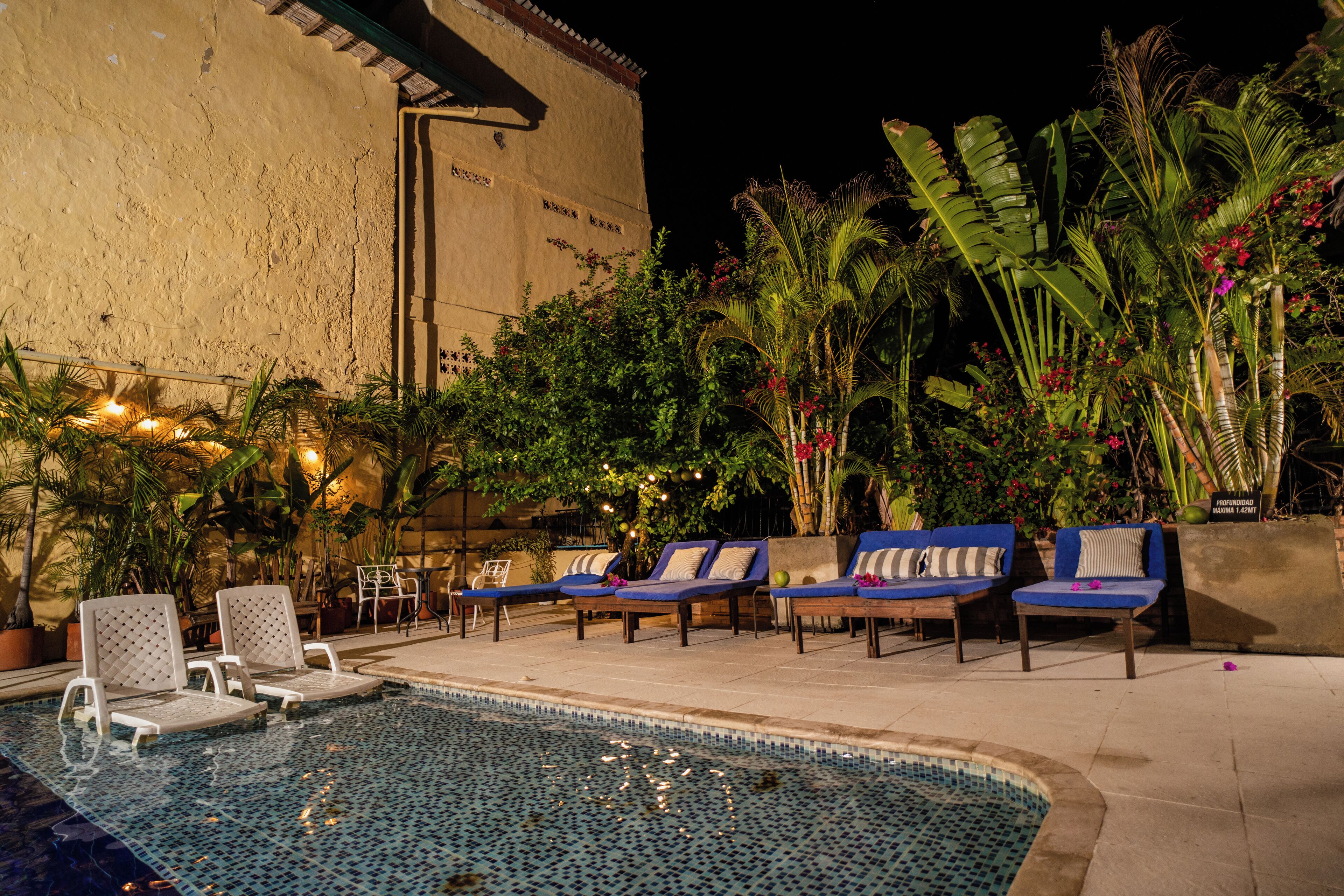 Uma área de piscina com espreguiçadeiras e uma piscina azulejada.