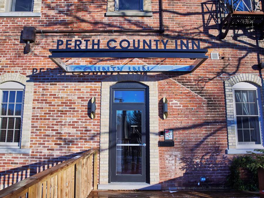 Um edifício de tijolos com uma placa que diz 'Perth County Inn'.