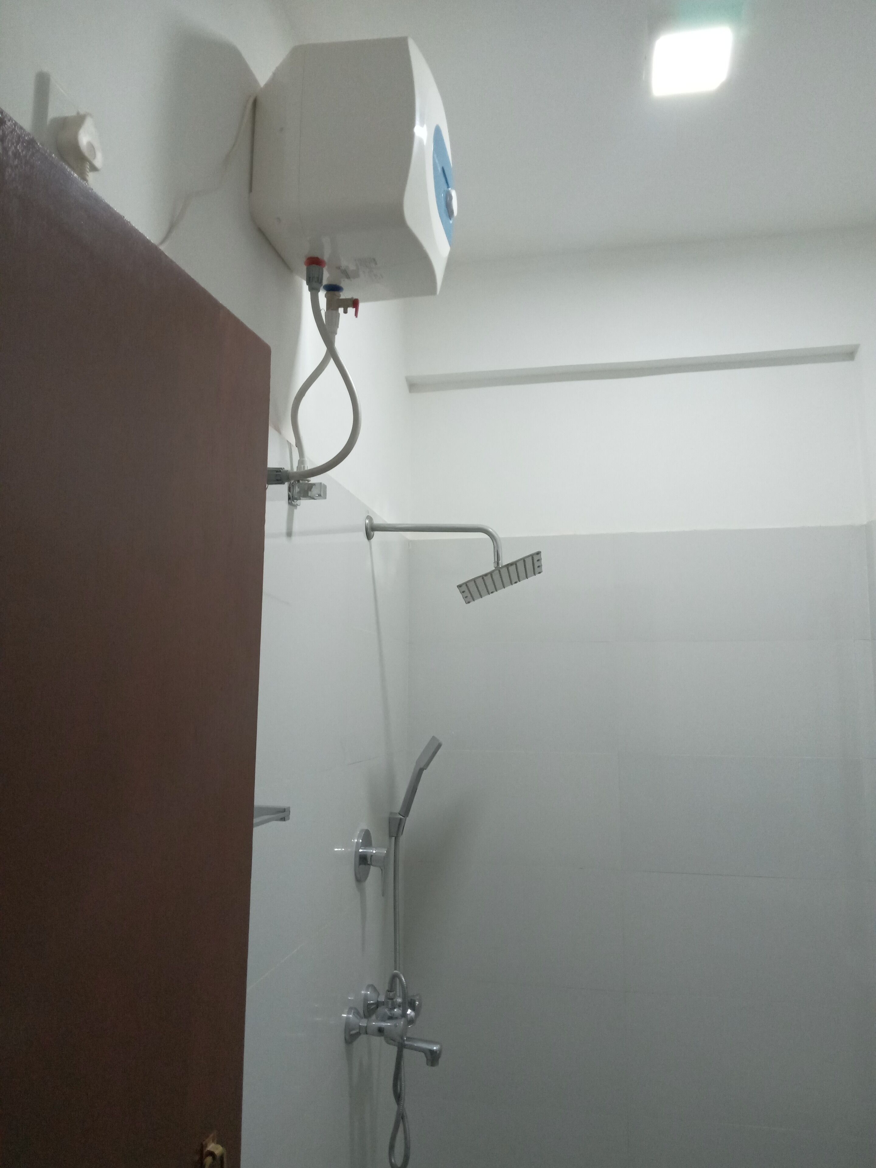 Casa de banho com chuveiro, secador de mãos e porta-toalhas.