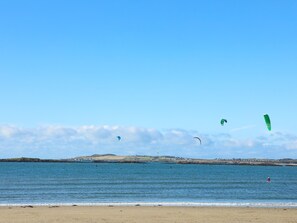 Uma praia com céu limpo e mar calmo.