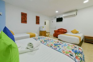 Quarto de hotel com duas camas, uma televisão fixada na parede e um aparelho de ar condicionado.