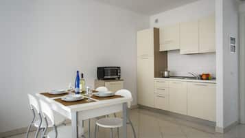 Um frigorífico/congelador grande, um micro-ondas, uma placa de cozinha