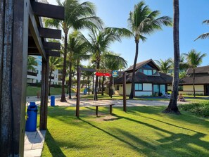 Um resort com palmeiras, uma placa com 'Marriott Suites' e um edifício com telhado de azulejos.