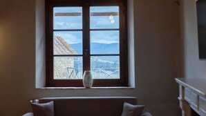 Quarto com uma grande janela com vista para uma paisagem montanhosa.