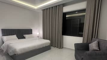 Um quarto moderno com cama, sofá, janela com cortinas e luminária no teto.