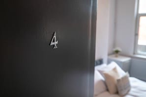 Close-up de uma parede preta com uma placa de metal com o número 4.
