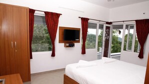 Quarto com cama, televisão e guarda-roupa.