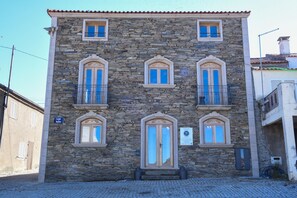 Um edifício de pedra com seis janelas em arco e varandas.