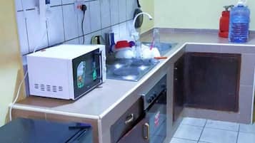 Apartamento Empresarial | Cozinha privada | Um frigorífico, um micro-ondas, utensílios de cozinha