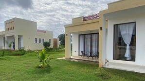 Um edifício moderno com telhado plano, grandes janelas e um pequeno pátio com cadeiras.