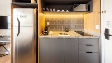 Um frigorífico/congelador grande, um micro-ondas, uma placa de cozinha