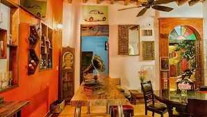 Um quarto aconchegante com teto de madeira, uma mesa de jantar, cadeiras e um ventilador de teto.