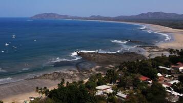 Uma vila costeira com praia, falésias e edifícios residenciais.