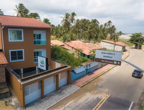 Um edifício de vários andares com uma placa indicando 'BEM-VINDA A MUNDÁU Rio Mundáu'.