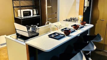 Um frigorífico, um micro-ondas, utensílios de cozinha, Congelador