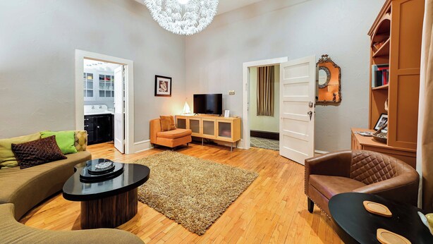 Uma sala de estar com sofá, mesa de centro, televisão e armário.