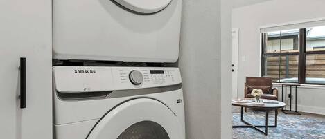Uma lavanderia com duas máquinas de lavar roupa empilhadas.
