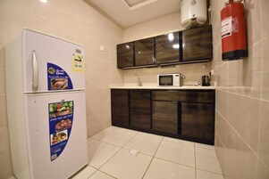 Minifrigorífico, um micro-ondas, grelhador, utensílios de cozinha