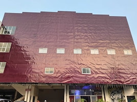 Um edifício com fachada cor de vinho, várias janelas e uma placa que diz 'Enjoy Life Music'.