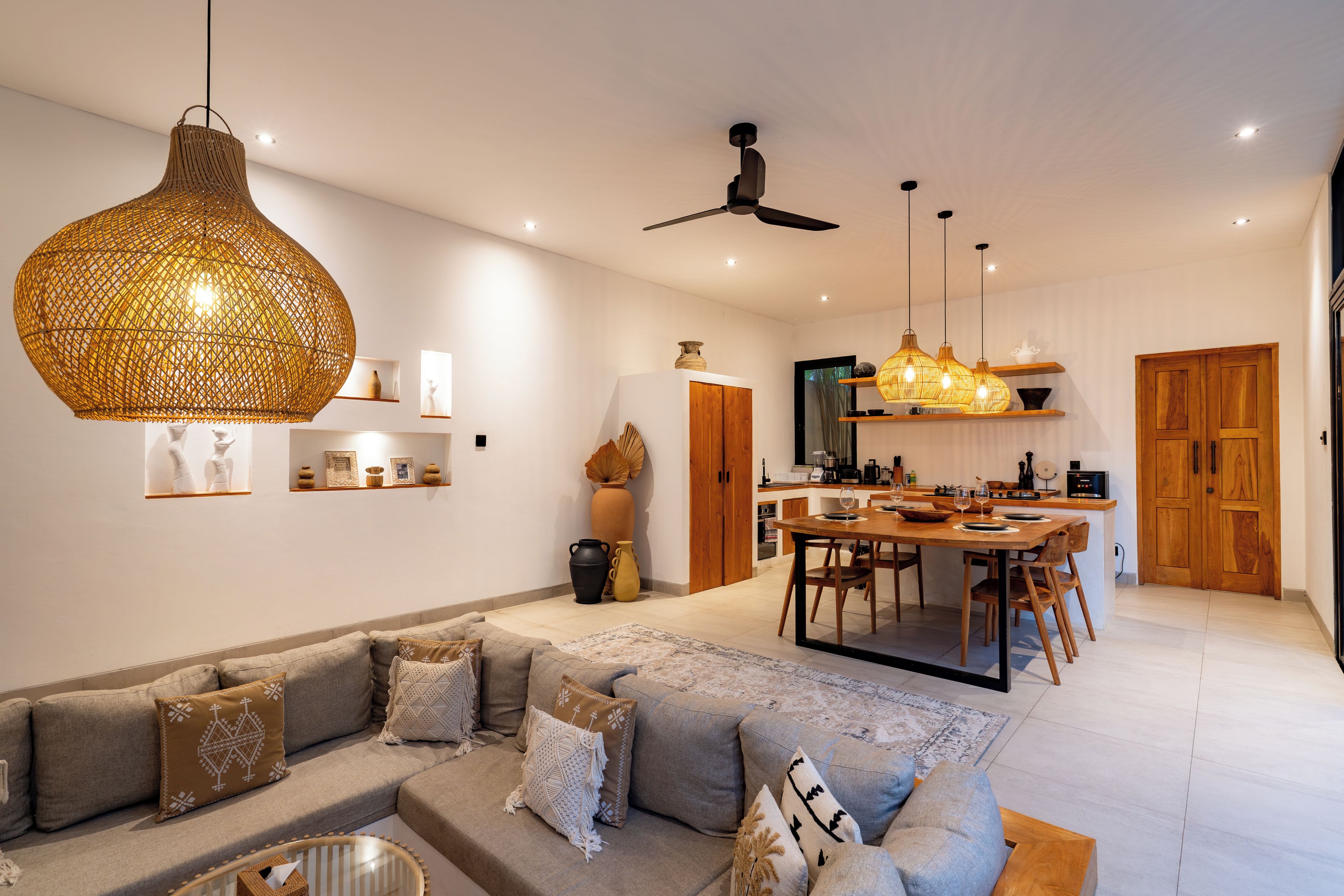 Uma sala de estar moderna com sofá, área de jantar e cozinha.