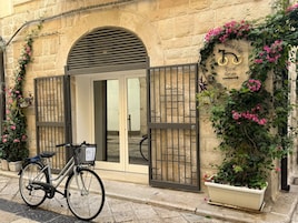 Um edifício com fachada de pedra, portão e uma bicicleta estacionada na frente.