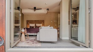 Um quarto moderno com uma cama grande, um sofá, uma mesinha e um ventilador de teto.