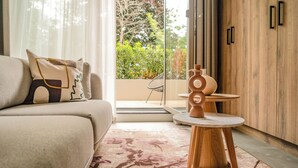 Uma sala de estar moderna com um sofá, uma mesa redonda pequena e um armário de madeira.