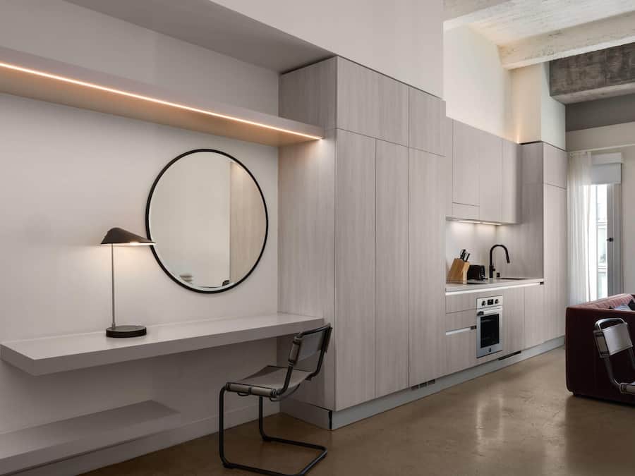 Uma cozinha moderna com forno embutido, um espelho redondo e um design minimalista.
