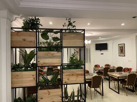 Uma sala de jantar com divisórias de madeira, várias mesas e cadeiras.