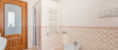 Casa de banho com sanita, bidé e zona de duche.