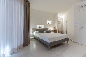 Um quarto moderno com uma cama, uma mesa de cabeceira, um espelho e um guarda-roupa.