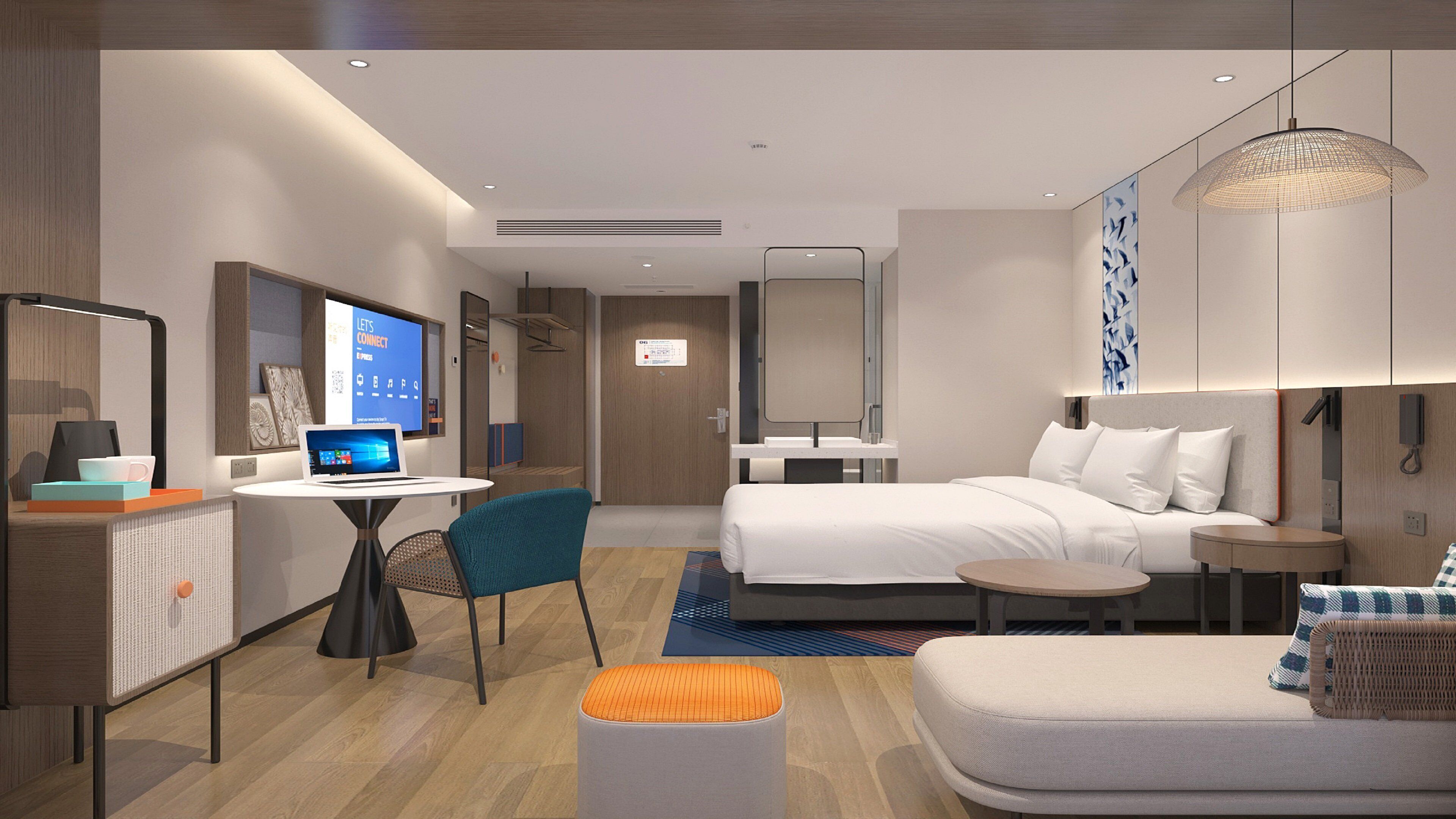 Quarto de hotel moderno com cama, escrivaninha, cadeira, mesa pequena, sofá e luminária suspensa.