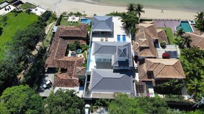 Vista aérea de um resort com vários edifícios, uma piscina e uma praia.
