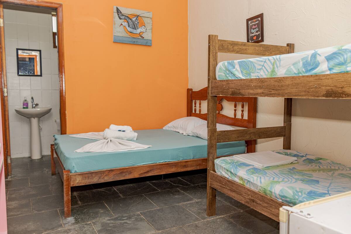 Quarto com duas beliches, uma pia e um espelho.