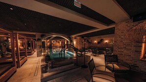 Uma área de spa com hidromassagem, assentos e uma parede de tijolos.