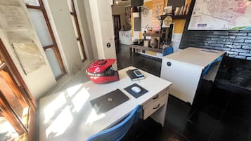 Um espaço de escritório compacto com uma mesa, cadeira e um capacete vermelho sobre a mesa.