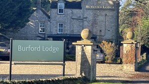 Um edifício de pedra com uma placa que diz 'Burford Lodge'.
