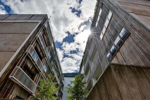 Um edifício moderno com fachada de madeira única e várias varandas.