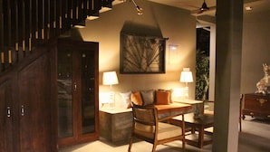 Uma sala de estar moderna com um sofá, cadeiras, uma mesa de centro e uma escada.